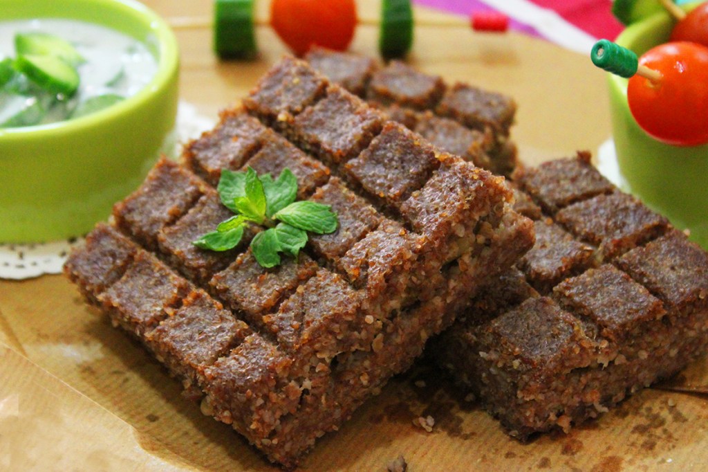 a traditional lebanese dish, kibbeh bil sanyeh (meat kibbeh in a flat ...